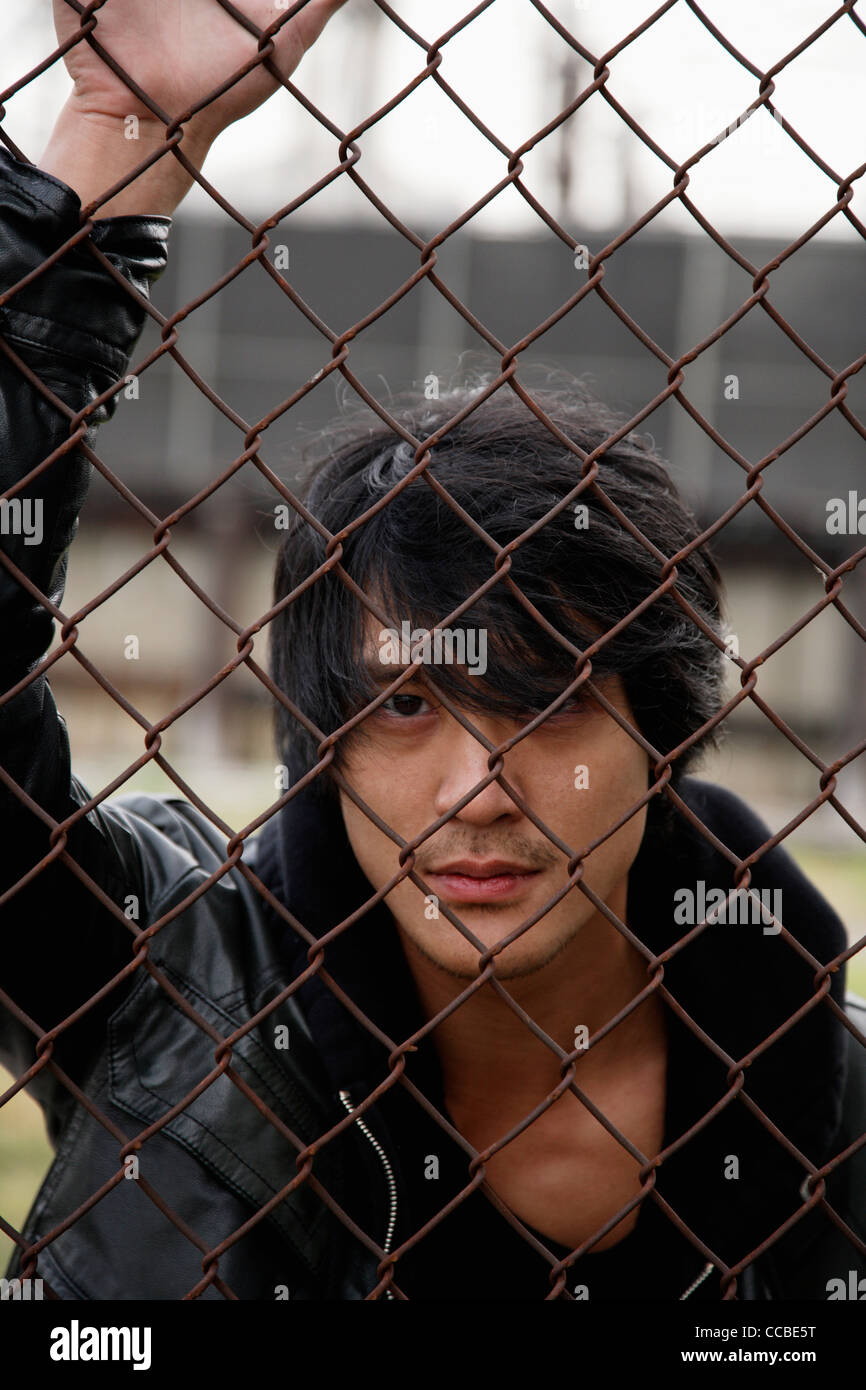 head shot of man looking through fence Stock Photo - Alamy