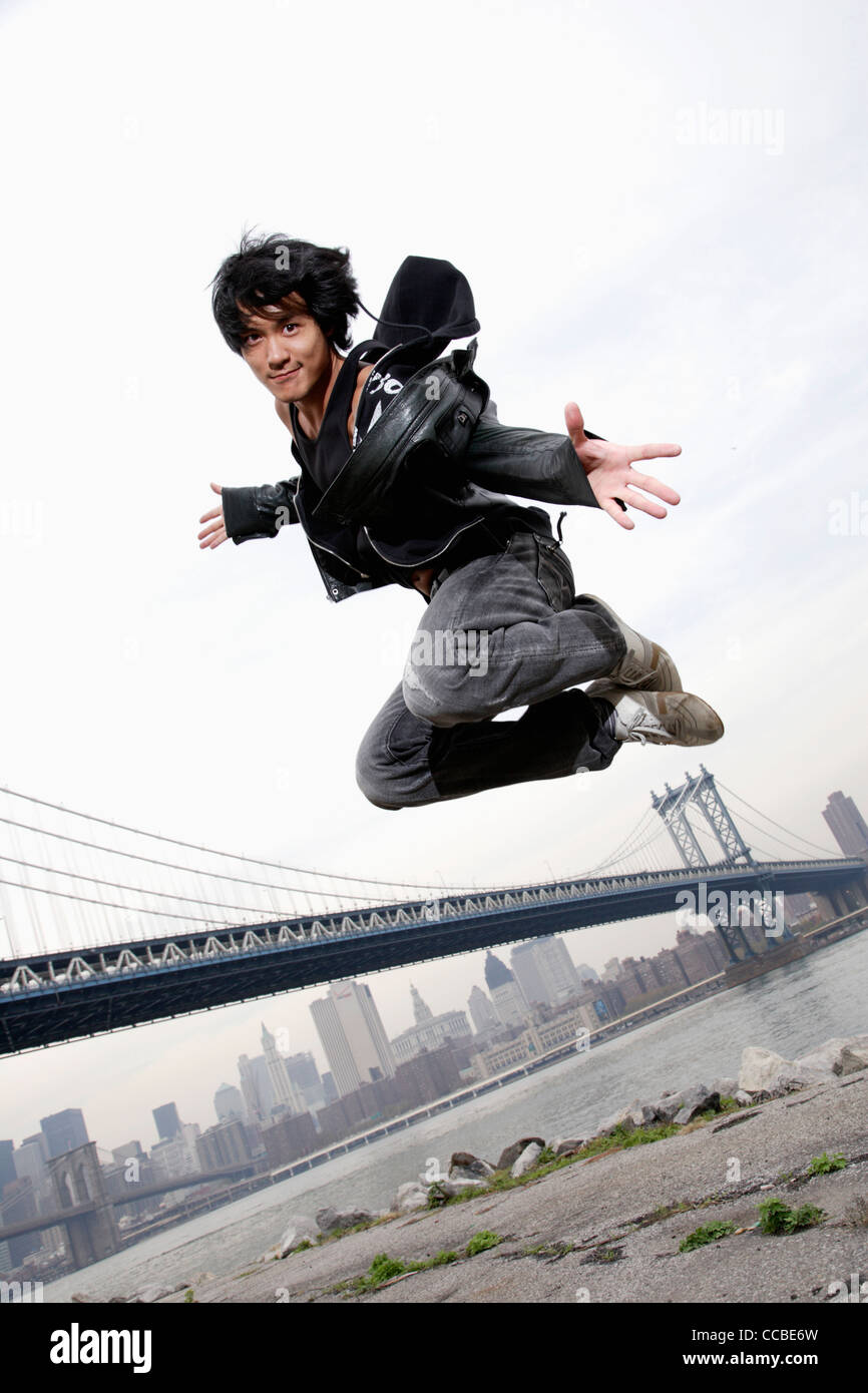 Man jumping high in the air in front of a bridge Stock Photo - Alamy