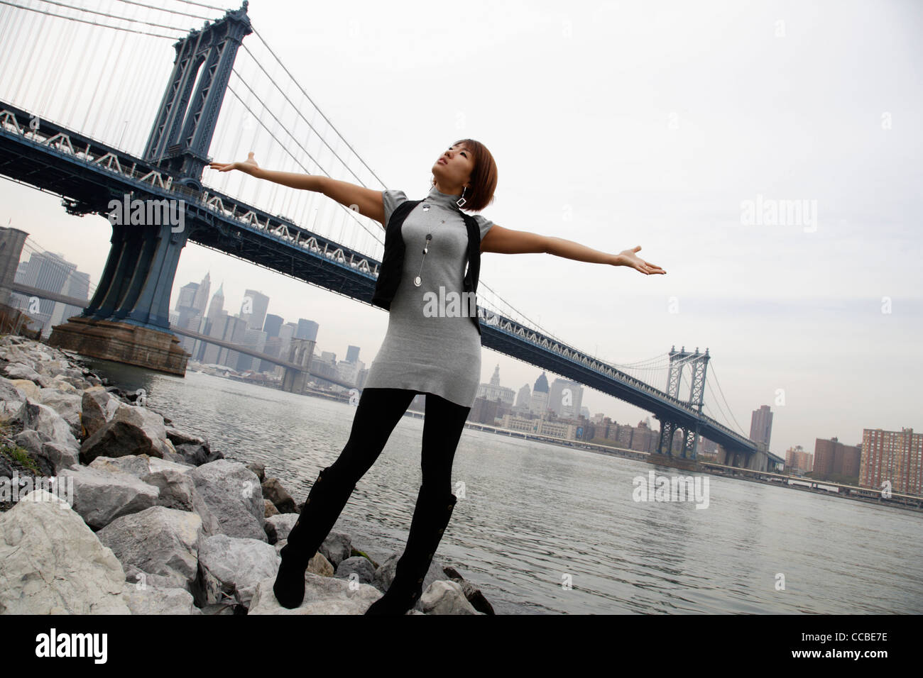 young woman standing in front of bridge with arms outstretched Stock ...