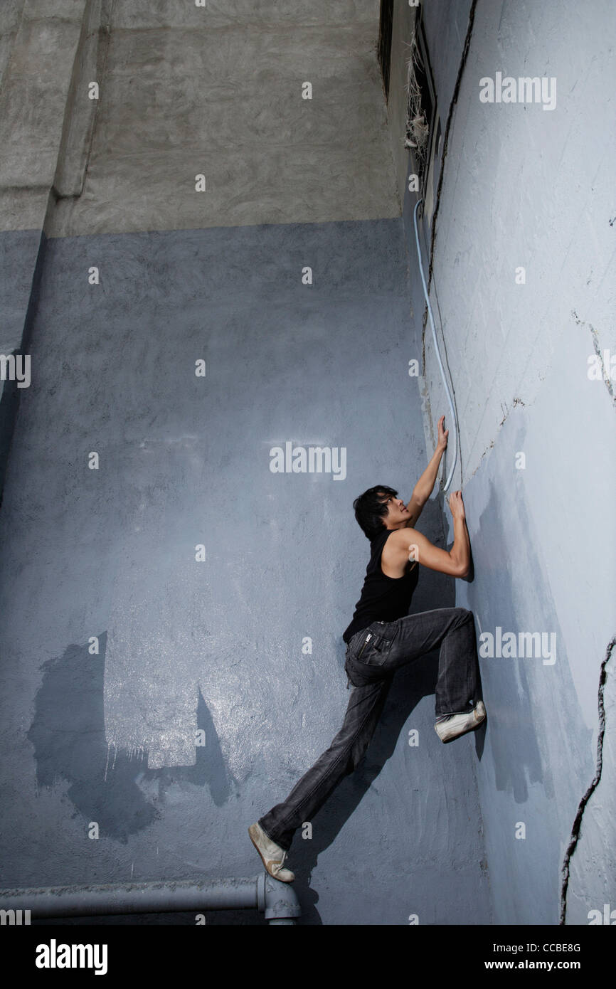 young man climbing wall Stock Photo - Alamy