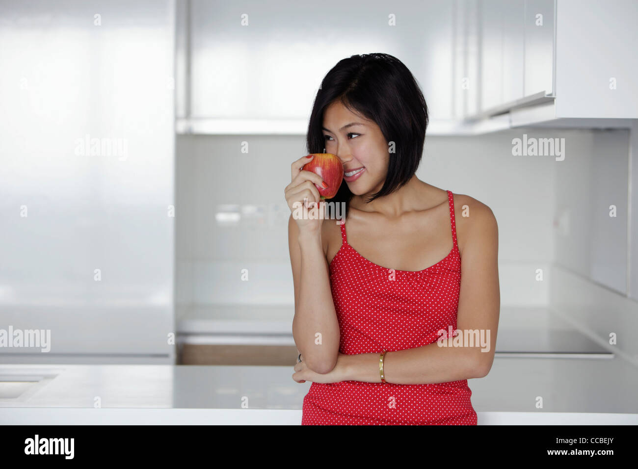 Woman holding smelling apple standing hi-res stock photography and ...
