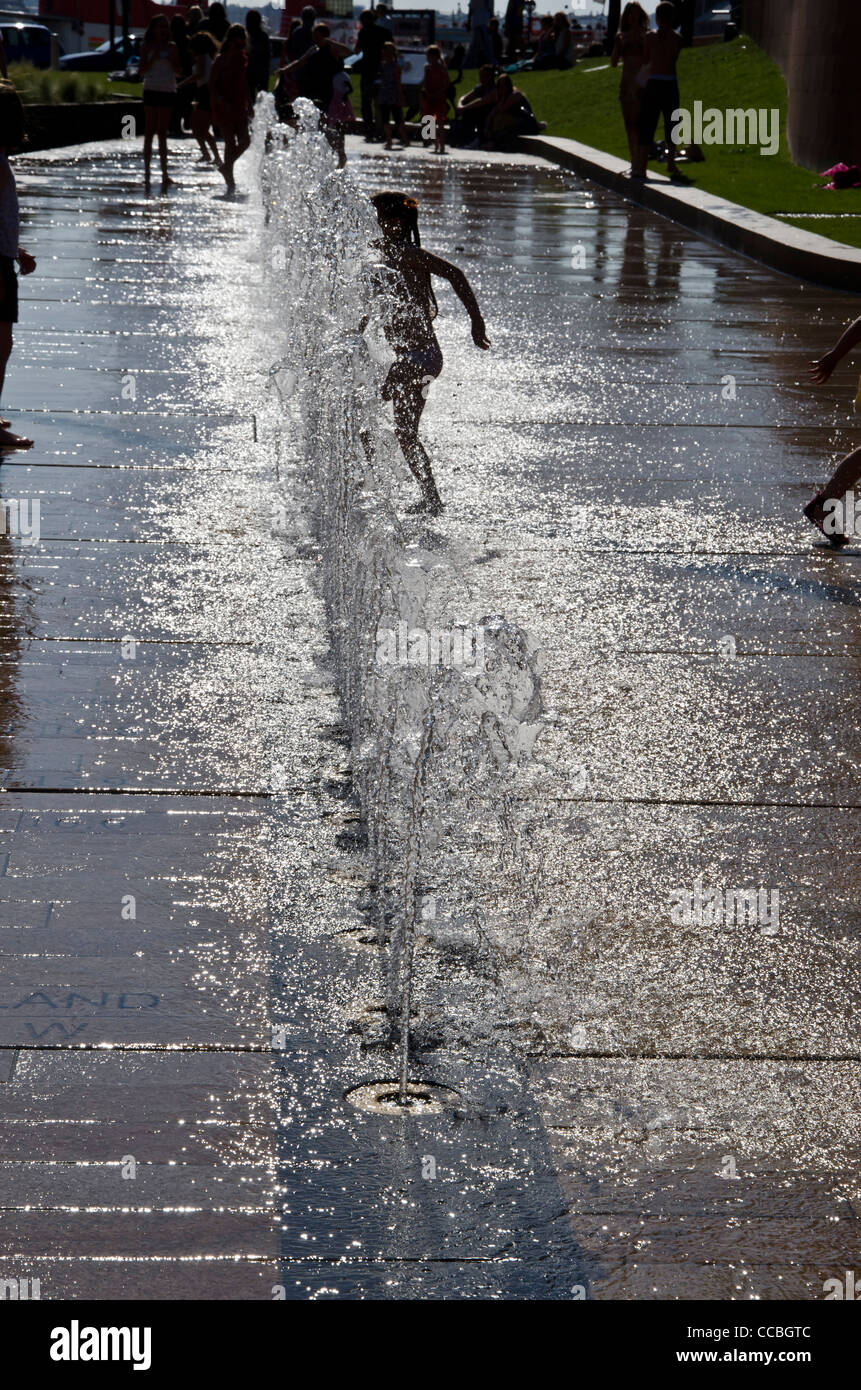 Children playing in a water feature in the centre of Liverpool, England ...