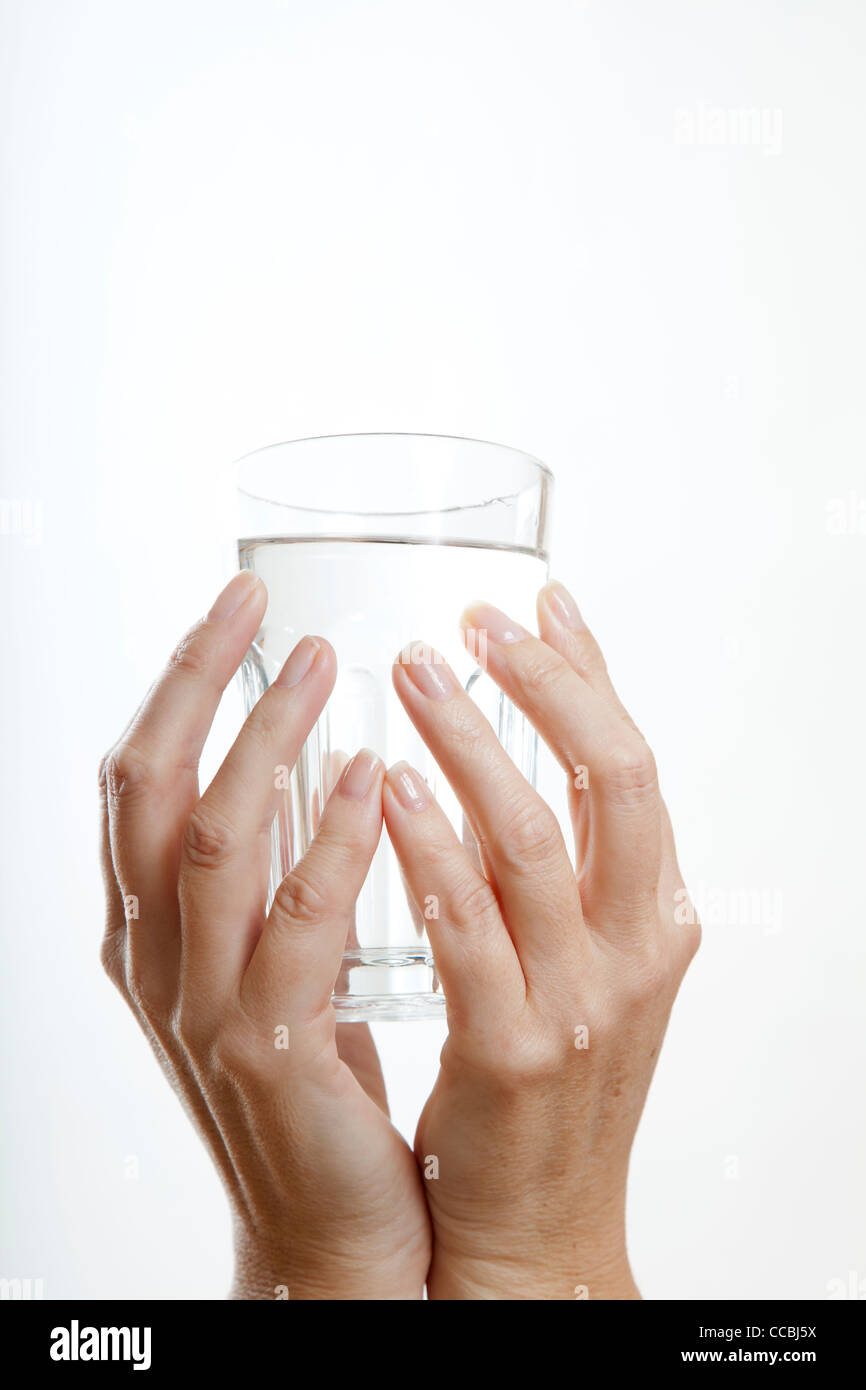 Woman's hands holding glass of water Stock Photo - Alamy