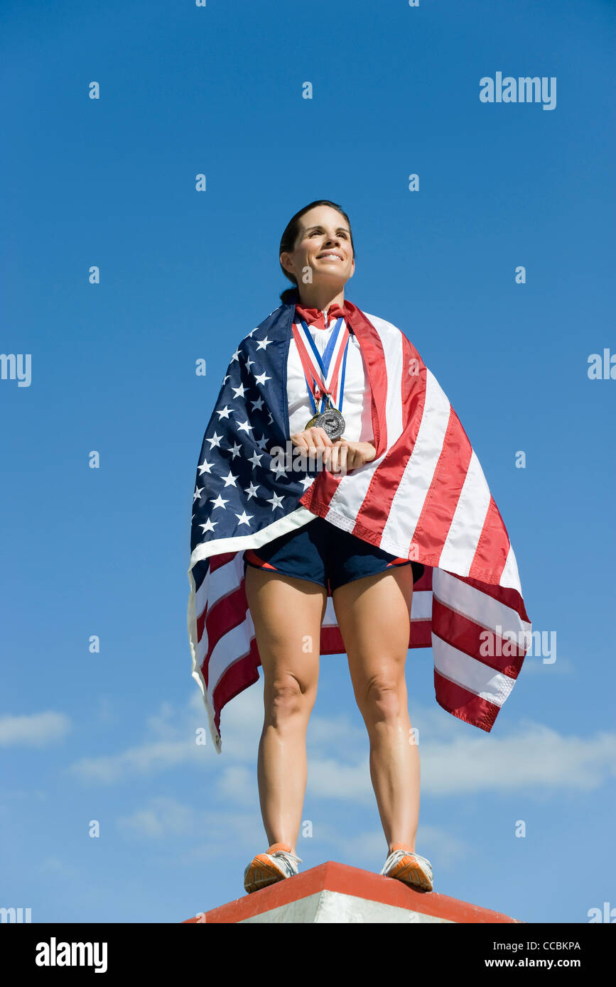 Female athlete being honored on podium, wrapped in American flag Stock ...