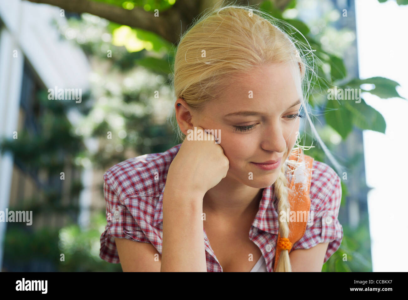 Young woman looking down in thought, portrait Stock Photo - Alamy