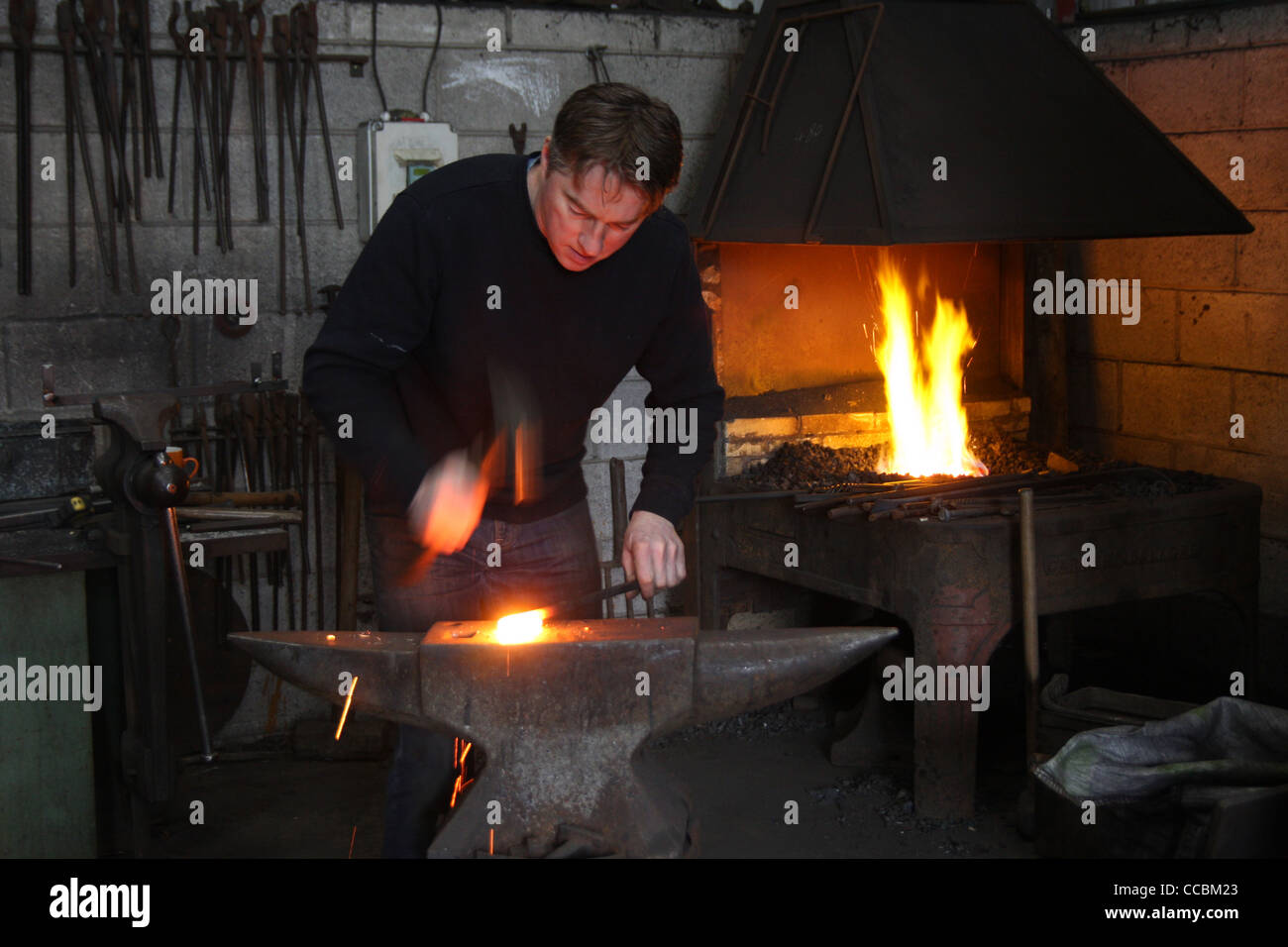 Metal being shaped at a forge Stock Photo - Alamy