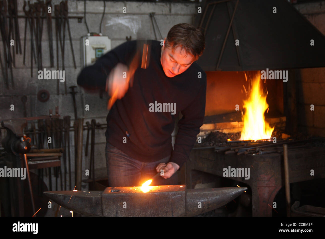 Metal being shaped at a forge Stock Photo - Alamy