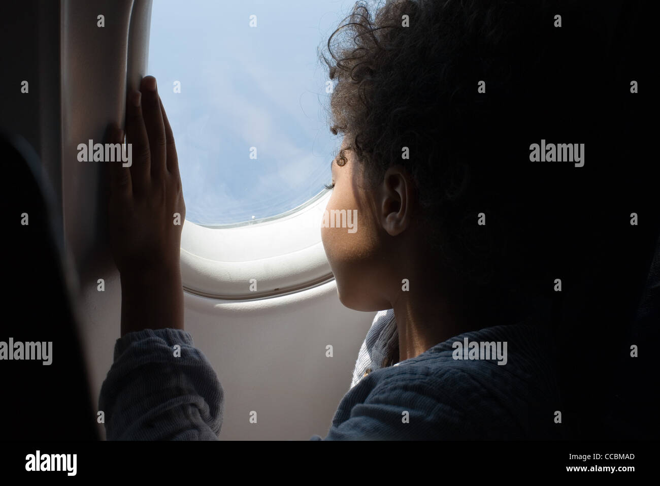 Boy looking out airplane window Stock Photo - Alamy