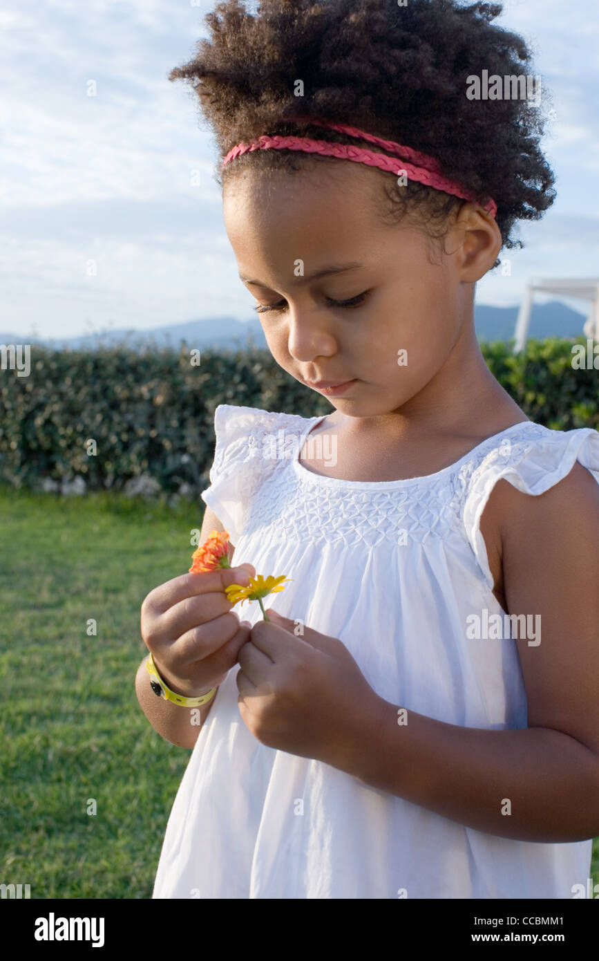 Little girl looking at flowers Stock Photo - Alamy