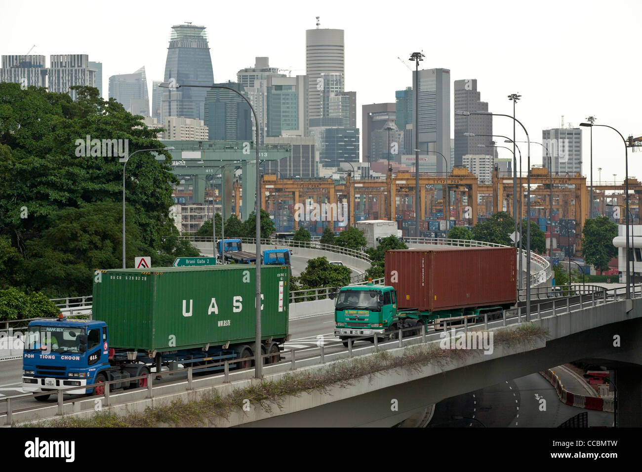 A truck transports a cargo container along an elevated section of road ...