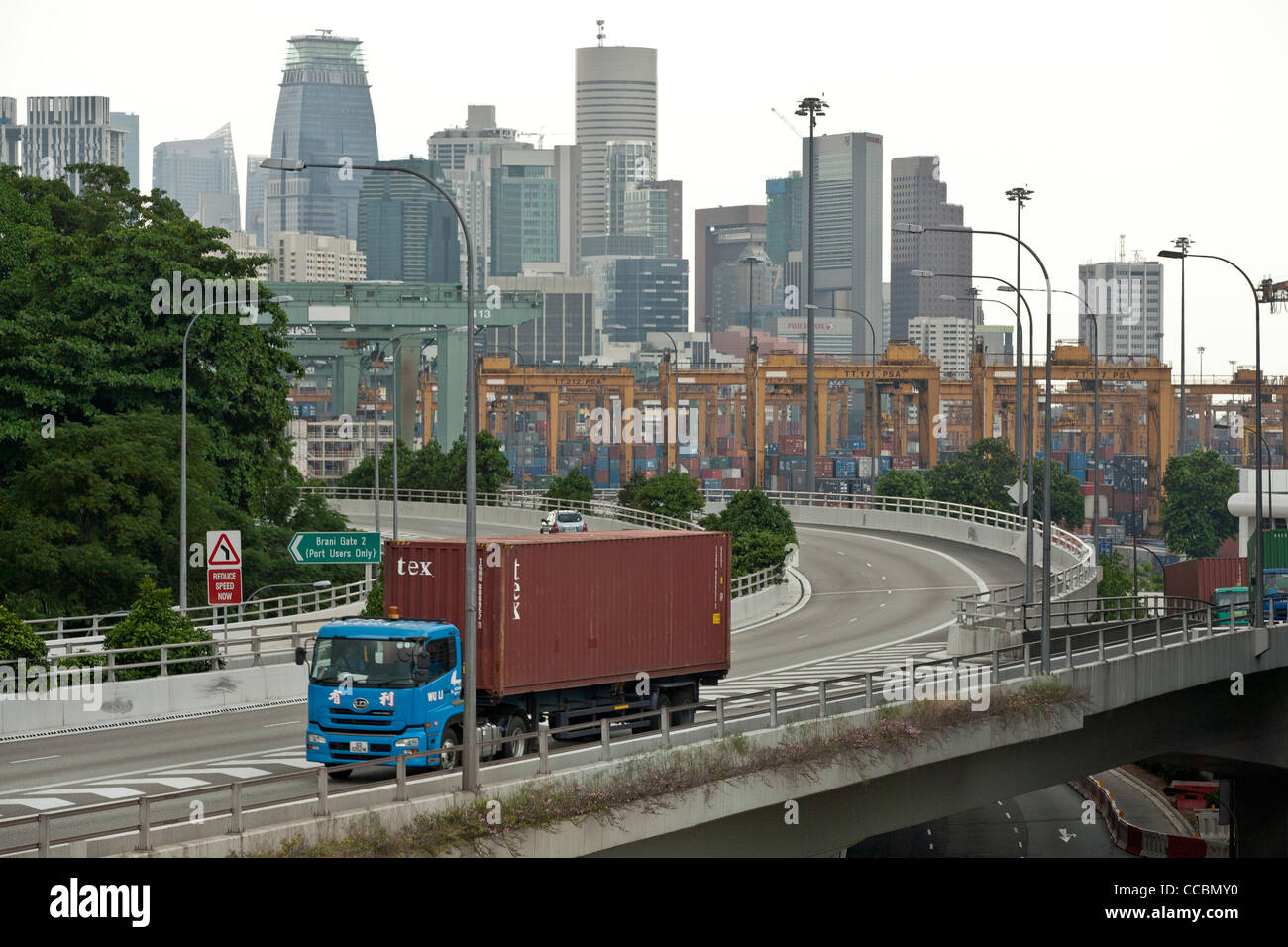 A truck transports a cargo container along an elevated section of road ...