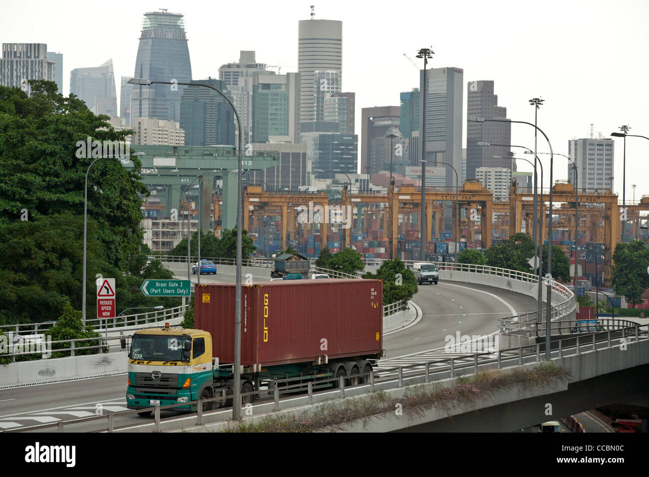 A truck transports a cargo container along an elevated section of road ...