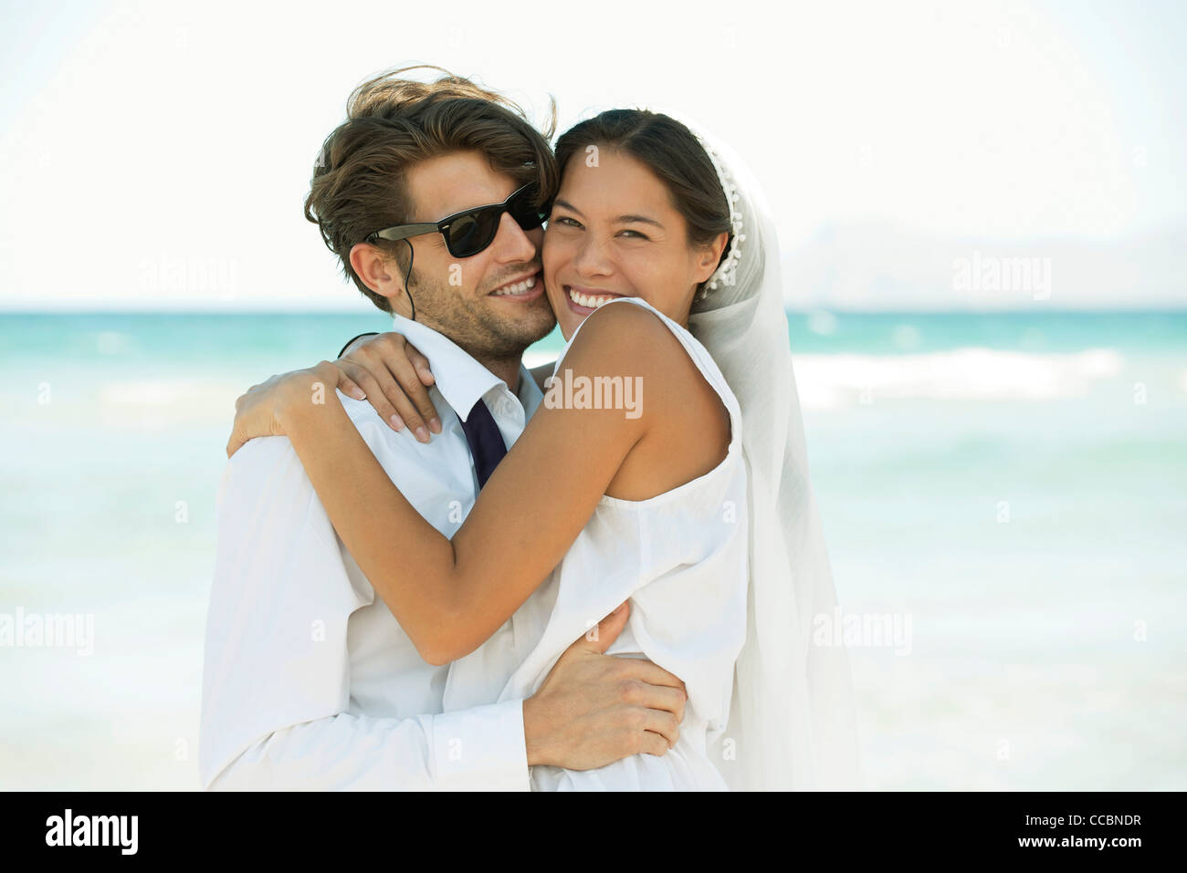 Bridge and groom embracing at the beach, portrait Stock Photo - Alamy