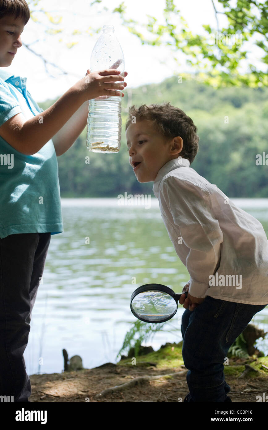 Children studying fish in water bottle Stock Photo - Alamy