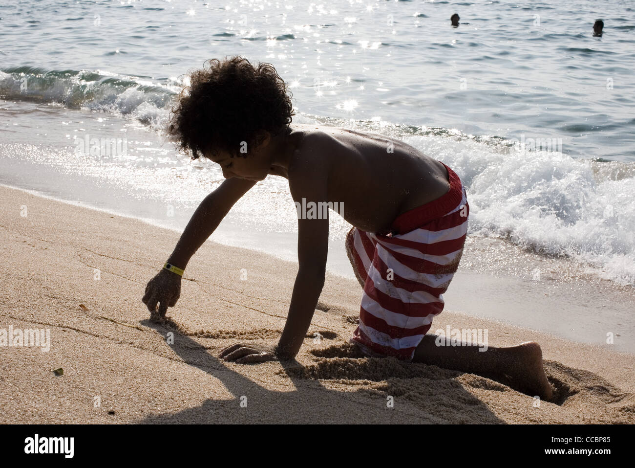 Boy kneeling in sand hi-res stock photography and images - Alamy