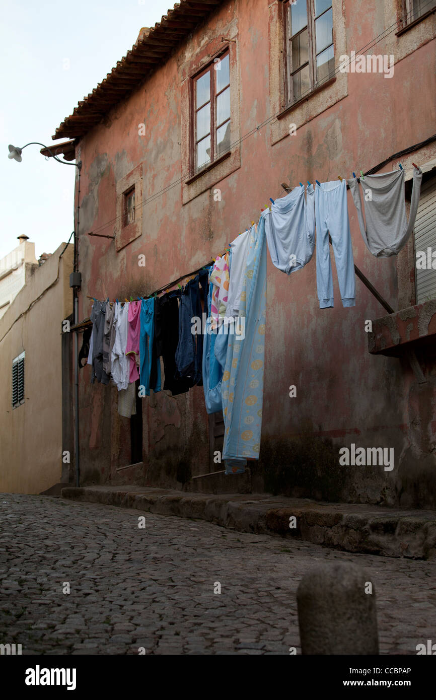 Outdoors clothes line sticking out a paved street Stock Photo - Alamy