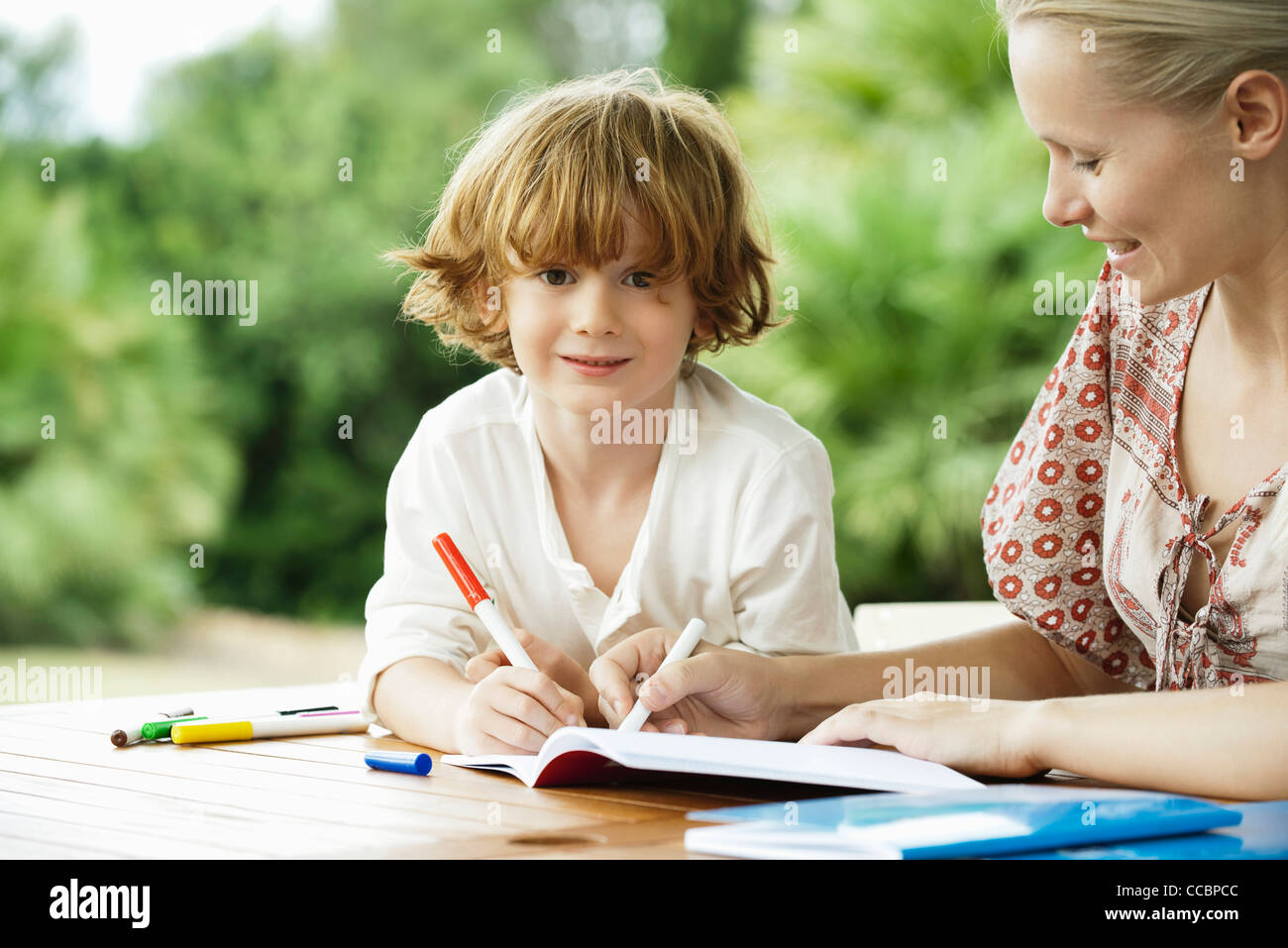 Boy coloring with his mother Stock Photo - Alamy