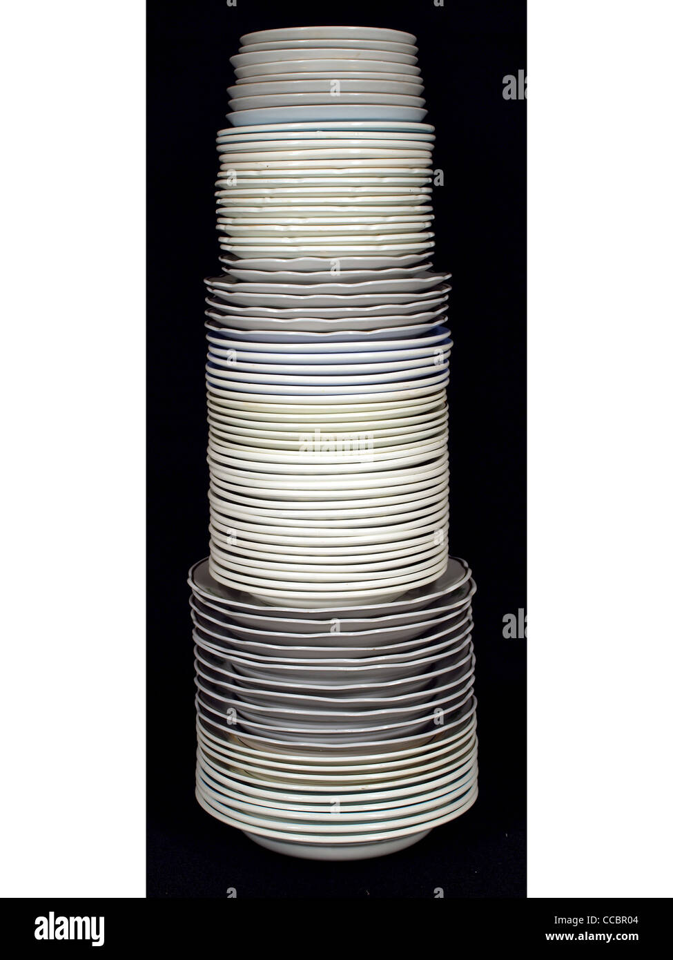 Plates in a stack on a black background Stock Photo - Alamy