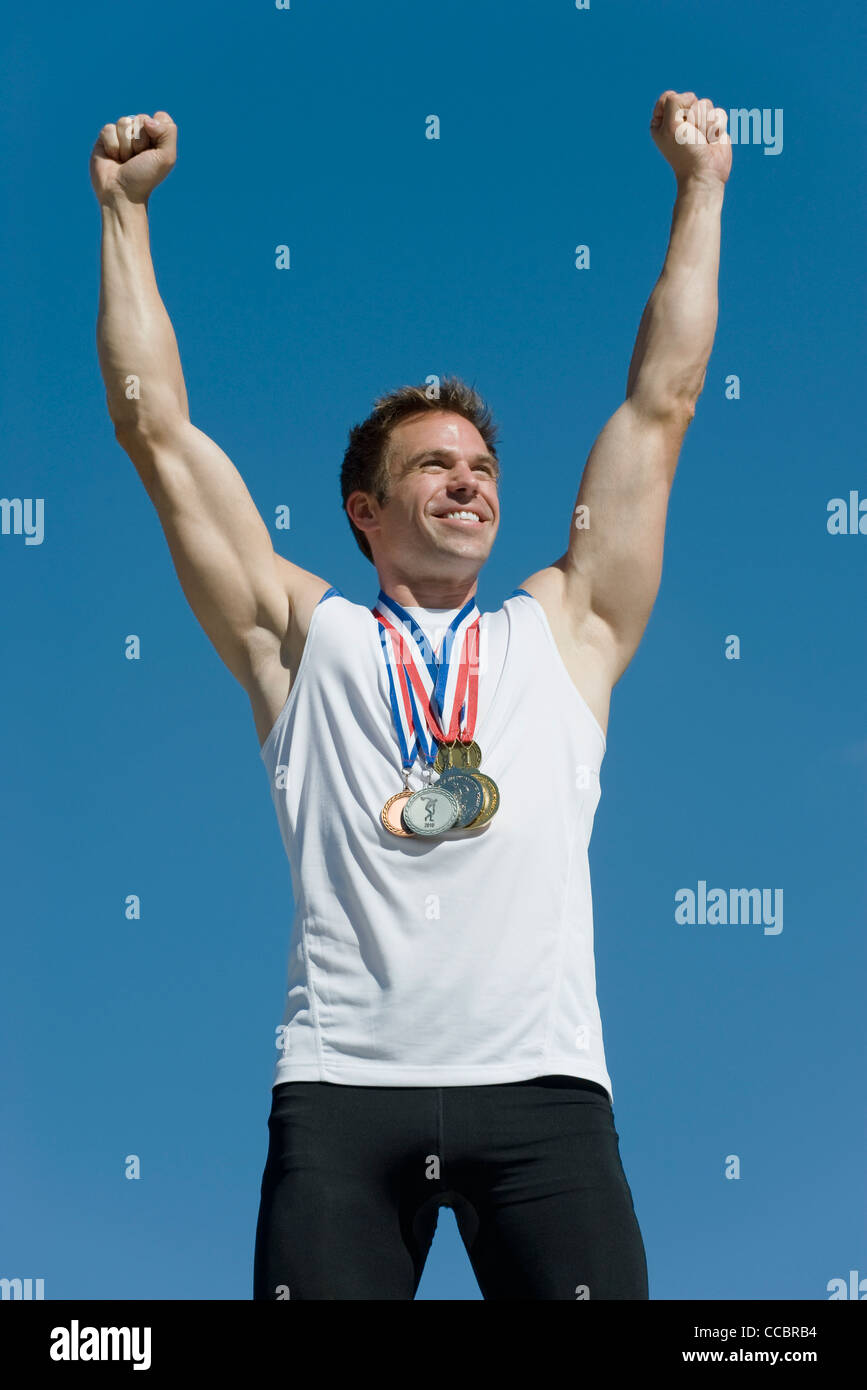 Male athlete with arms raised in victory Stock Photo - Alamy