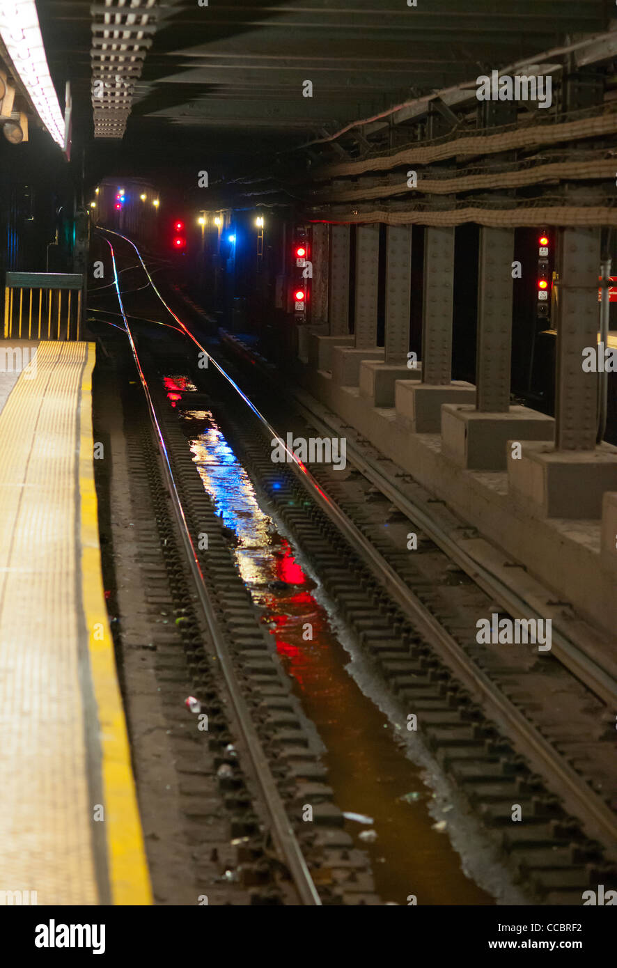 Signal lights are seen reflected in water in the subway track bed at ...