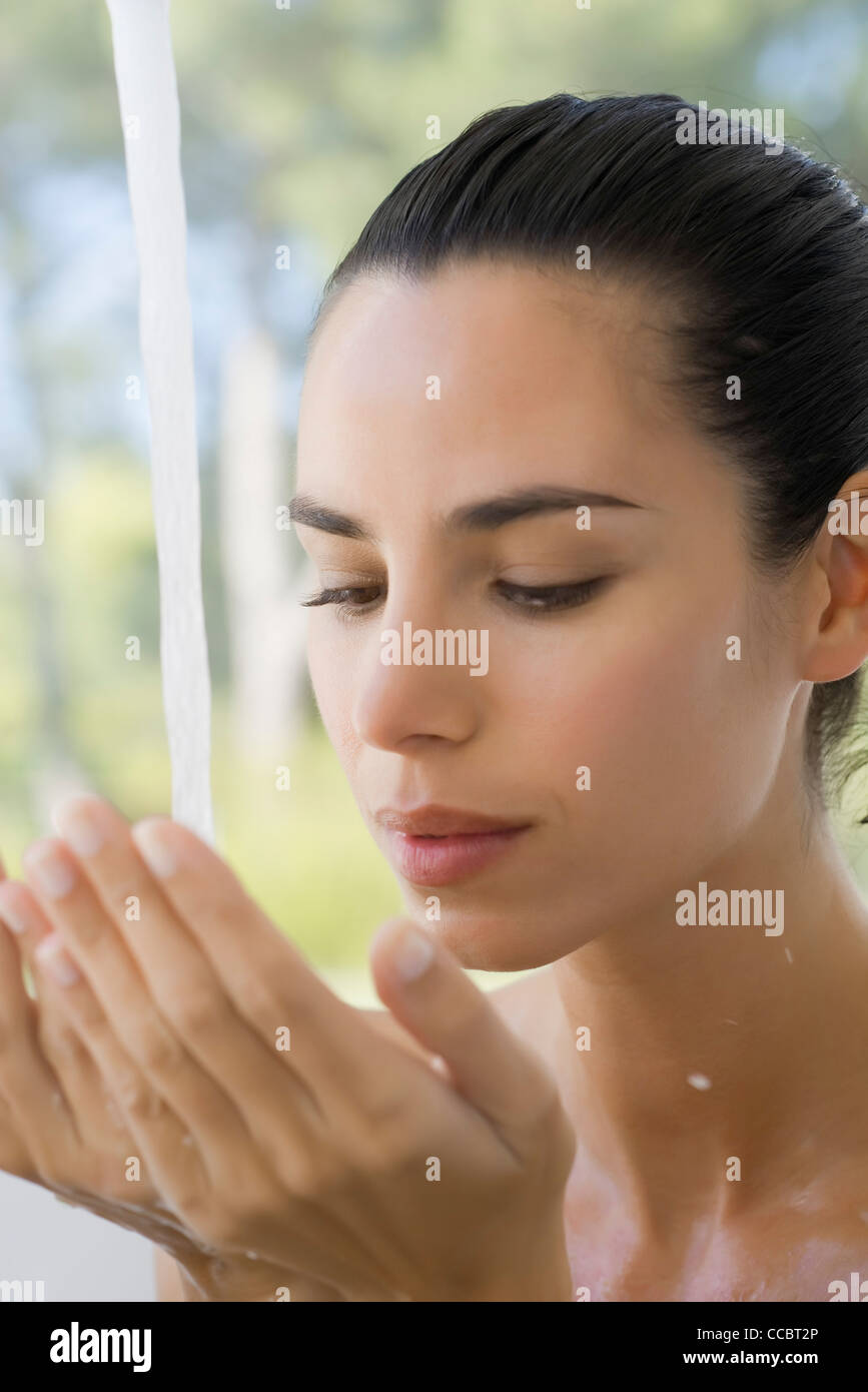 Woman with cupped hands under running water Stock Photo - Alamy