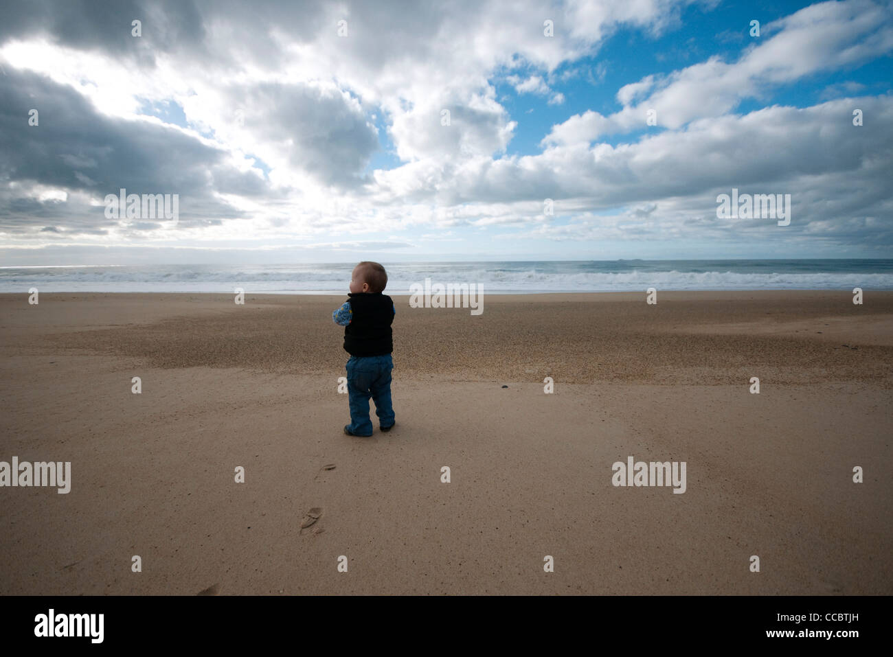 Toddler walking on beach, rear view Stock Photo - Alamy