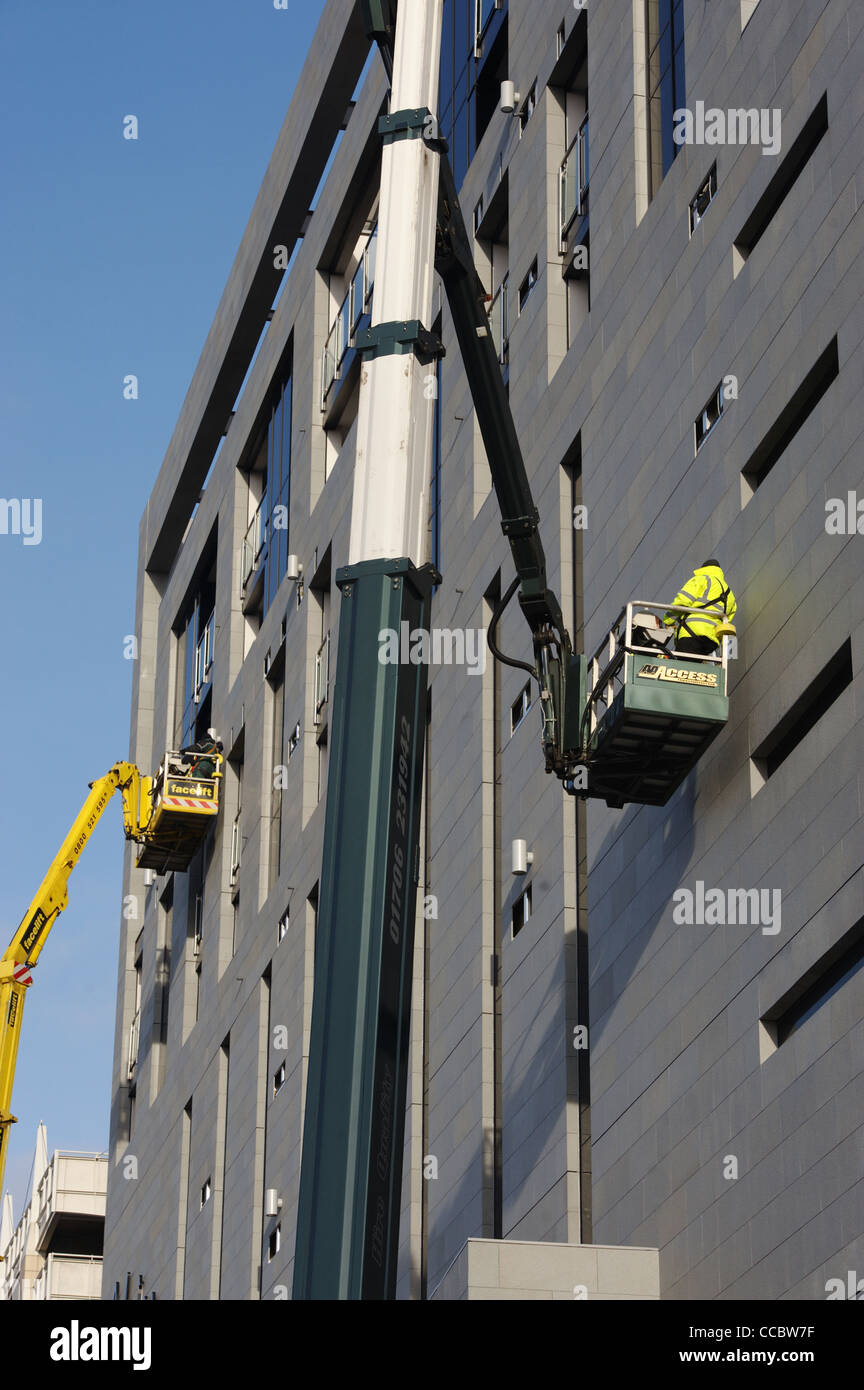 Cranes for maintenance workers on a tall building in Liverpool, England ...