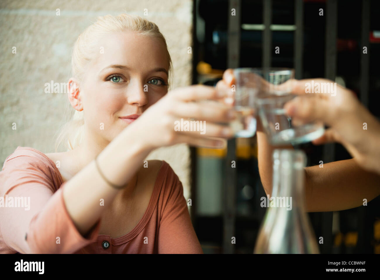 Young blond woman raising glass Stock Photo - Alamy
