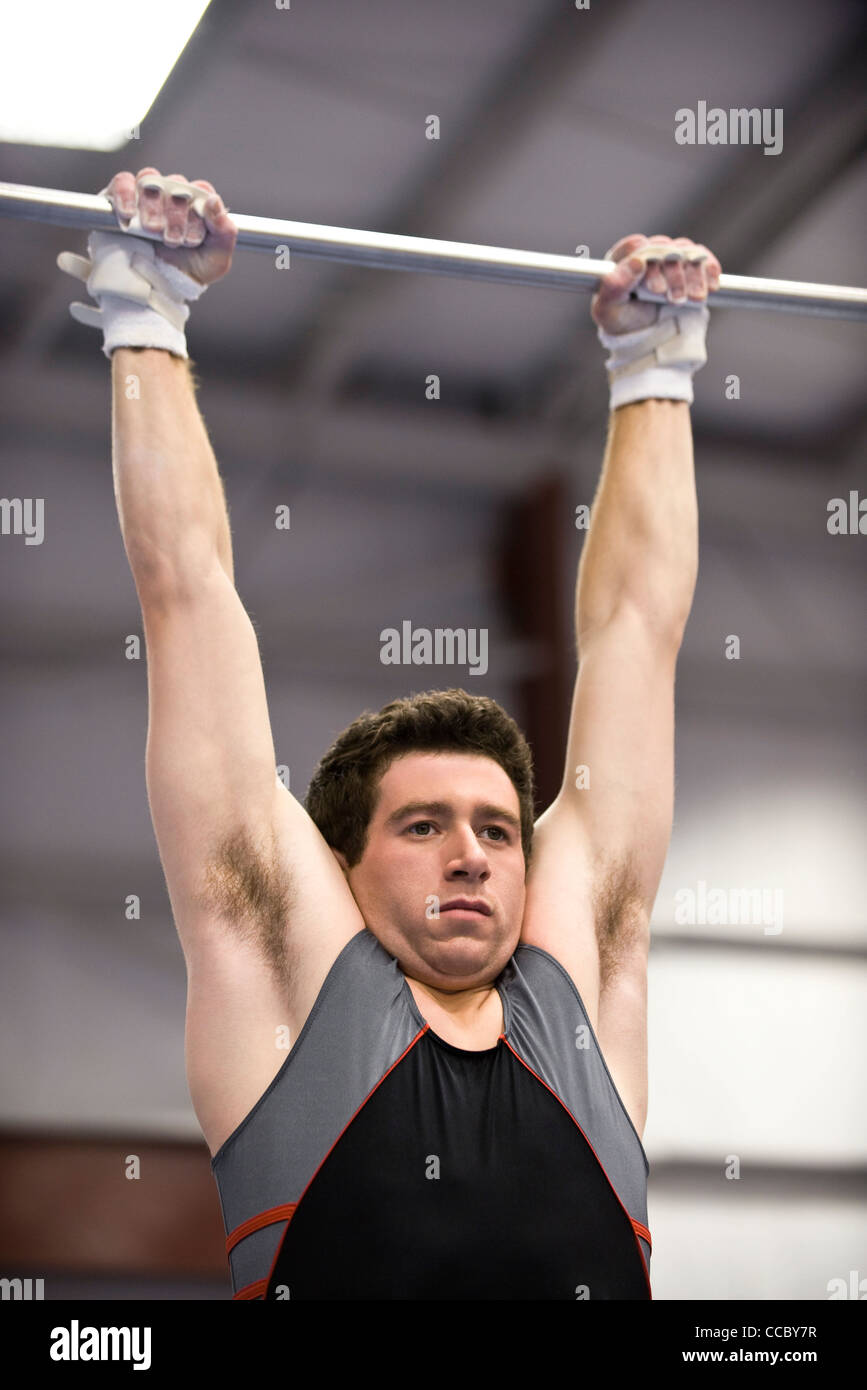 Male gymnast hanging from horizontal bar Stock Photo - Alamy