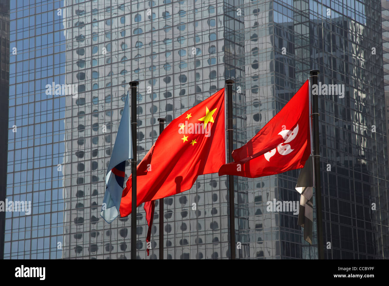 hong kong and chinese flags flying against office building downtown ...