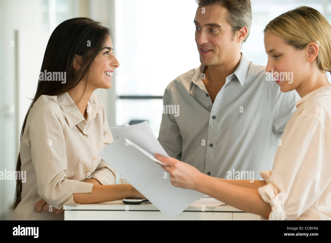 Colleagues talking together in office Stock Photo - Alamy