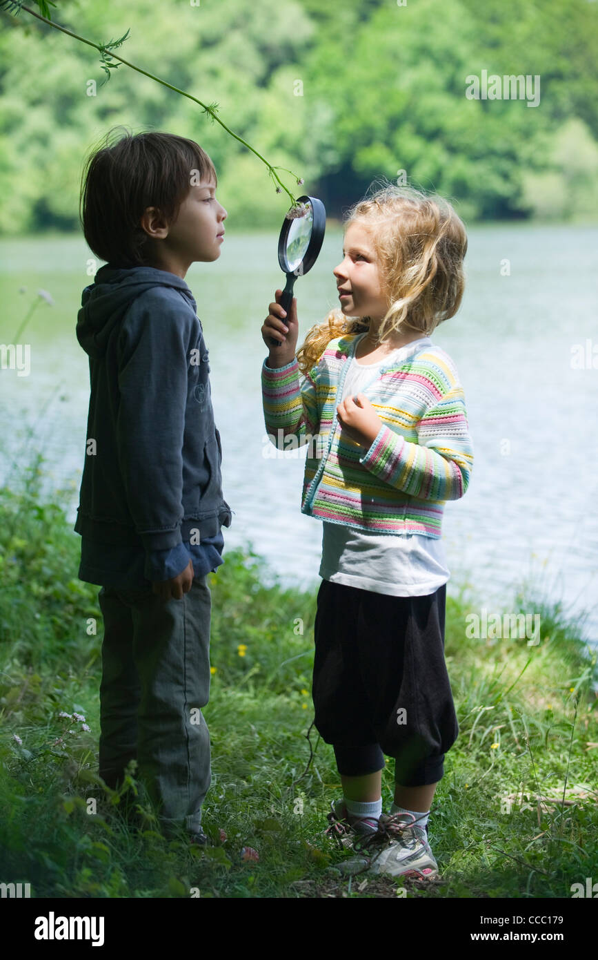 Children playing with magnifying glass outdoors Stock Photo - Alamy