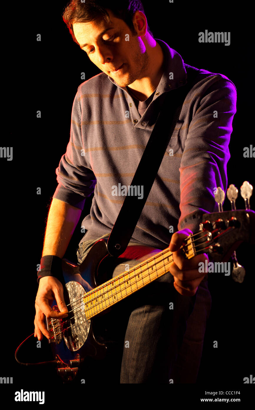 Man Playing Electric Bass on Black Background Stock Photo - Alamy
