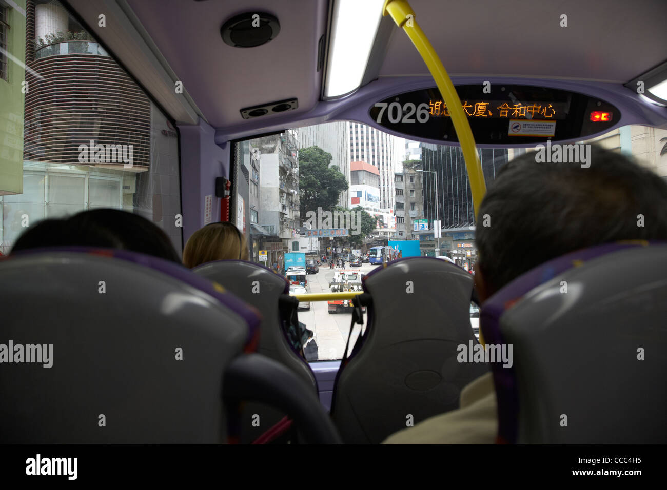 passengers on the top deck of a double deck bus going through the ...