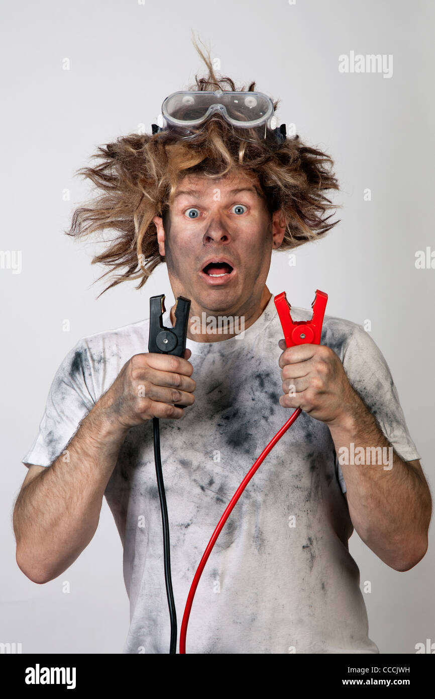 Surprised mechanic after an accident while incorrectly jumping a car ...