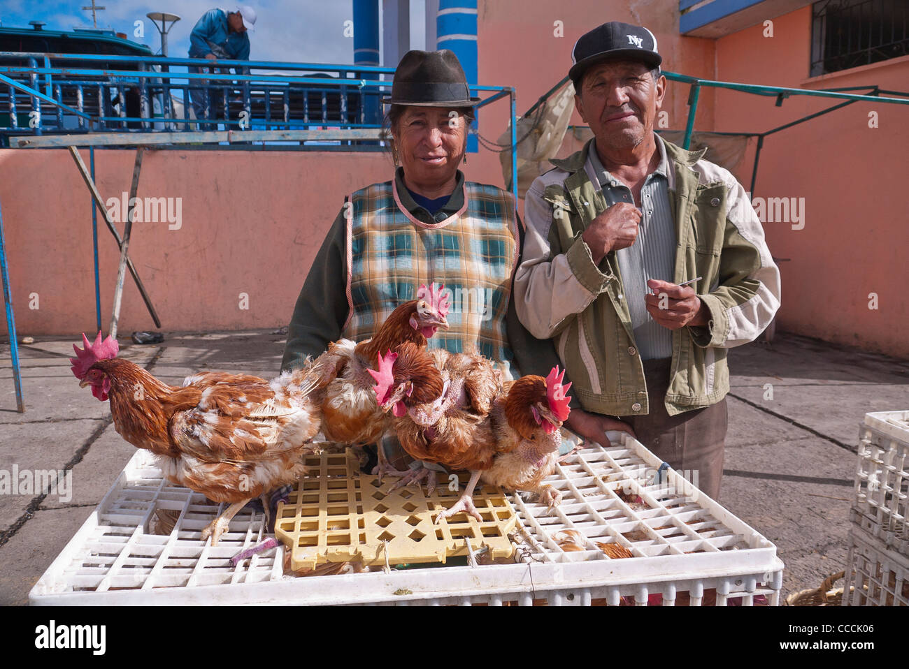 A man and his wife stand at their market stall where they sell live ...