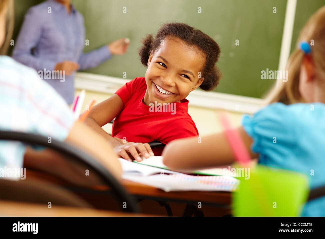 Portrait of cute girl looking at her classmate at lesson Stock Photo ...