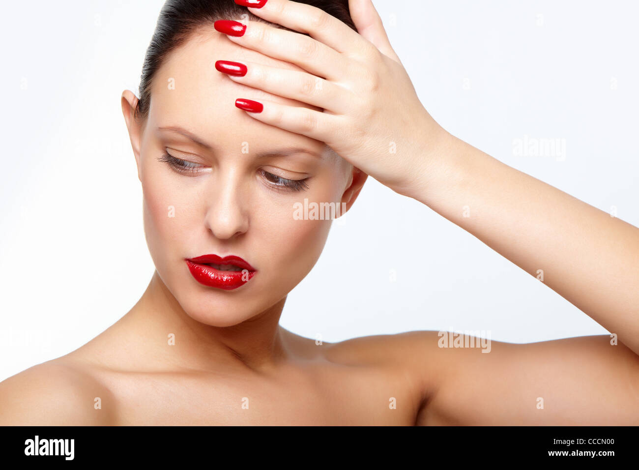 Posh woman with red lips and fingernails touching her forehead Stock ...