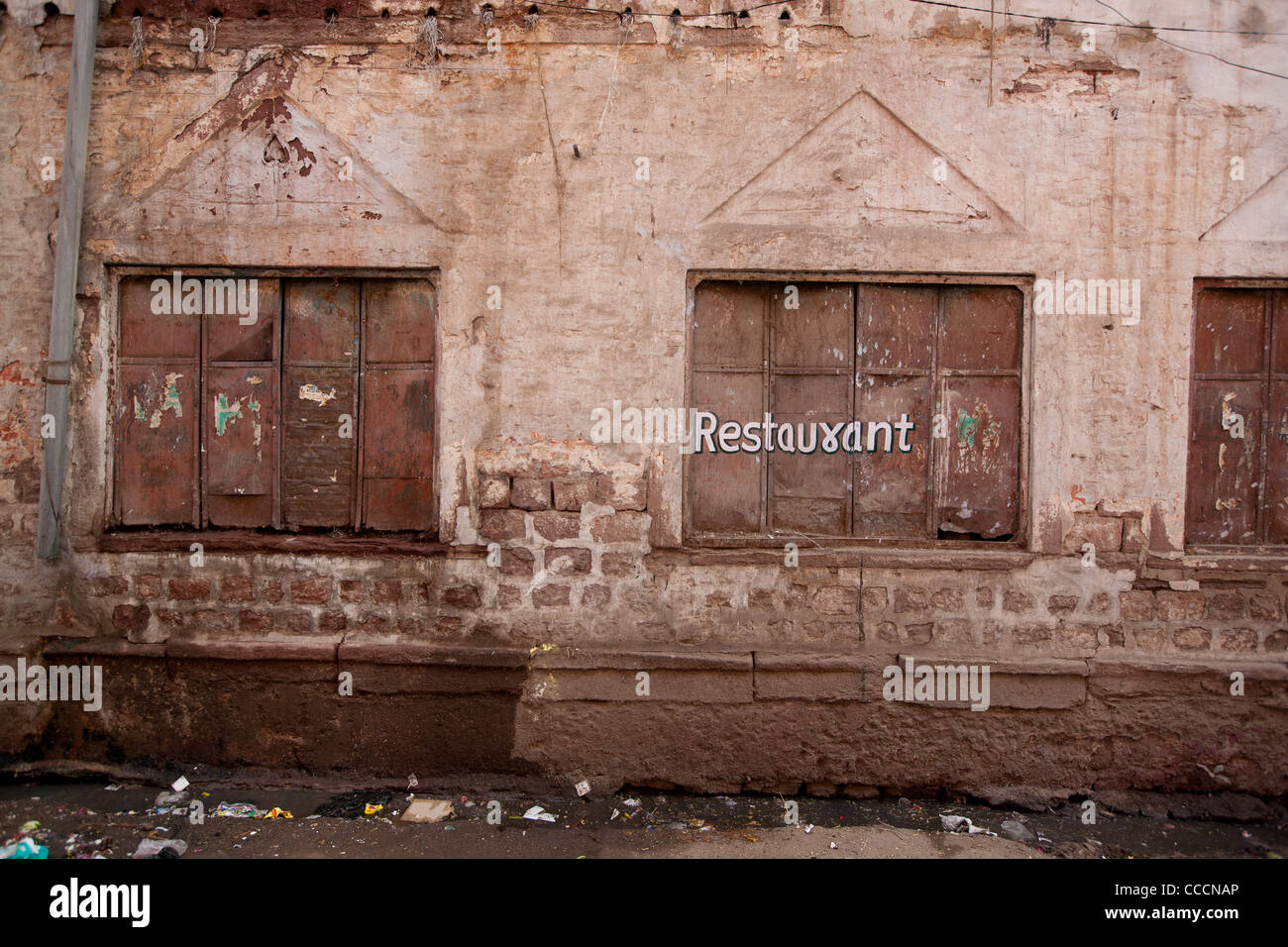 Broken building with a restaurant sign upon a window, the Sardar Market ...