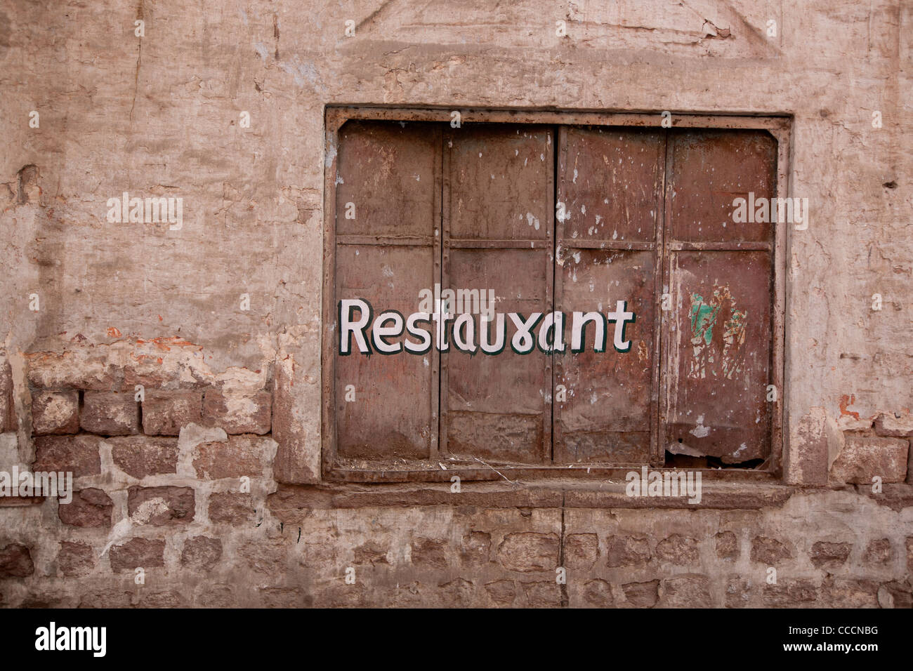 Broken building with a restaurant sign upon a window, the Sardar Market ...