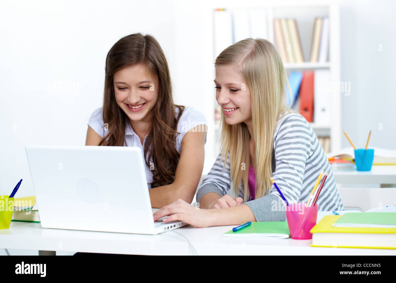 Cute girls working with laptop in college Stock Photo - Alamy