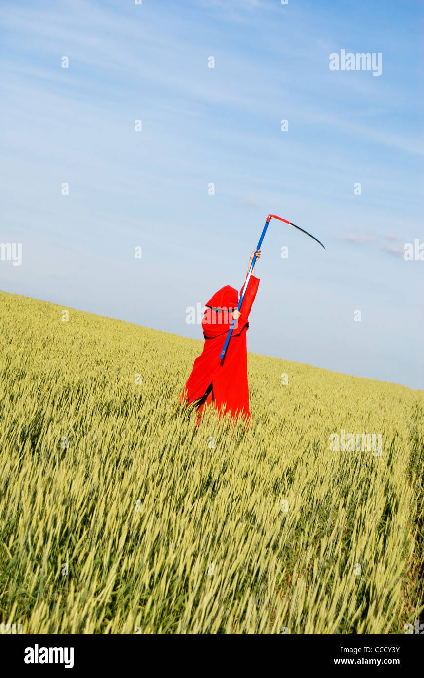 Spooky figure in red hood with a scythe Stock Photo - Alamy
