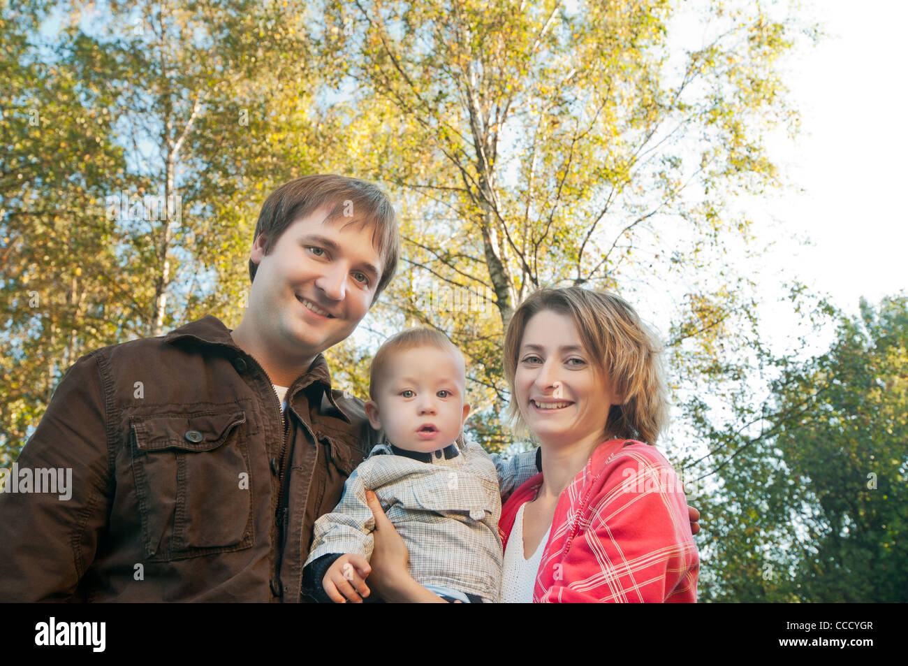 Happy parents holding their baby boy outdoors in the autumn Stock Photo ...