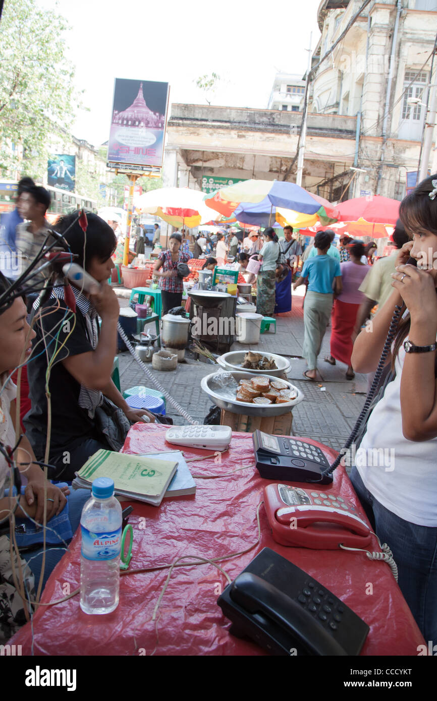 Woman is calling from improvised phone booth/box on the street market ...
