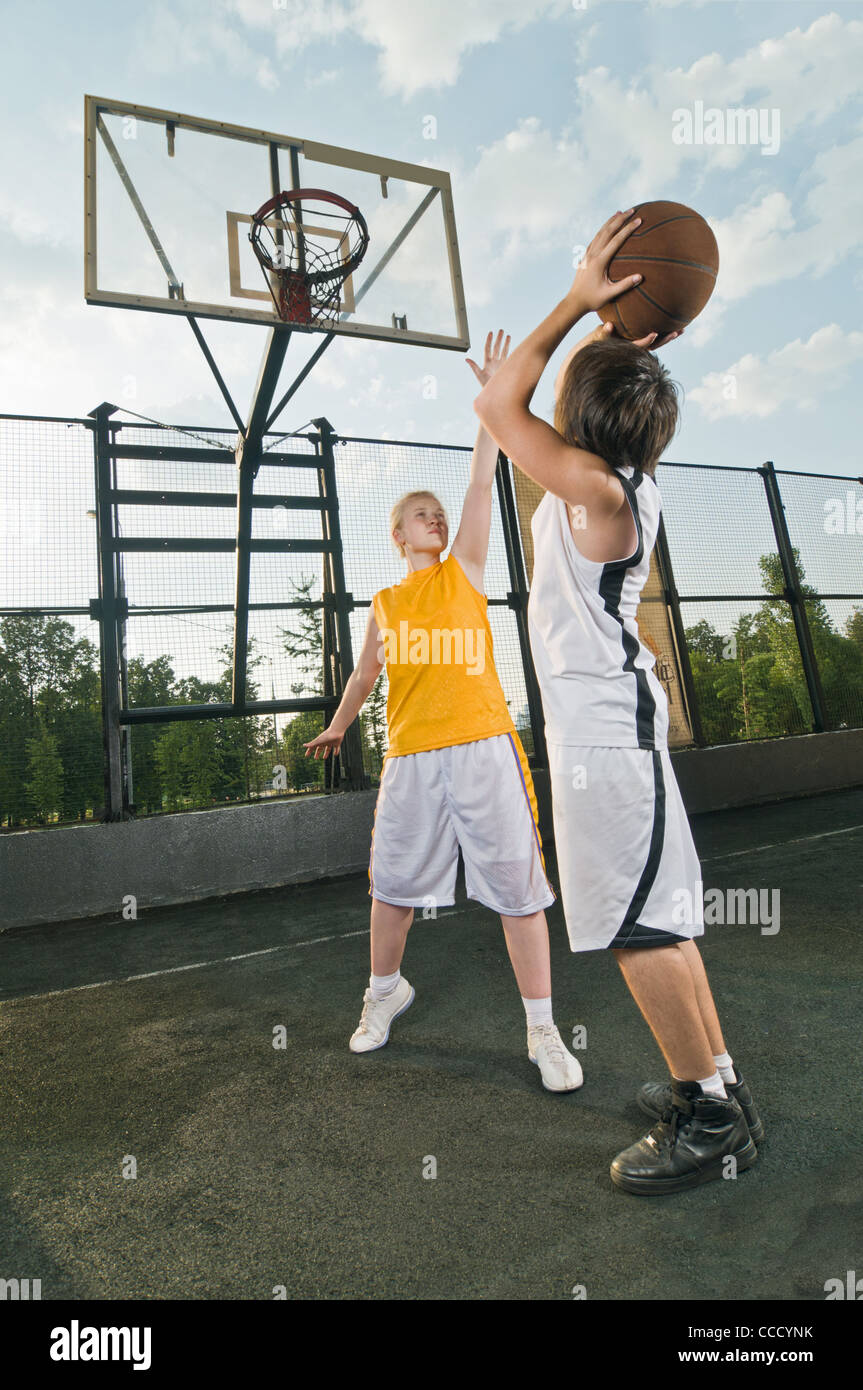 Two teenagers playing basketball at the street playground Stock Photo ...