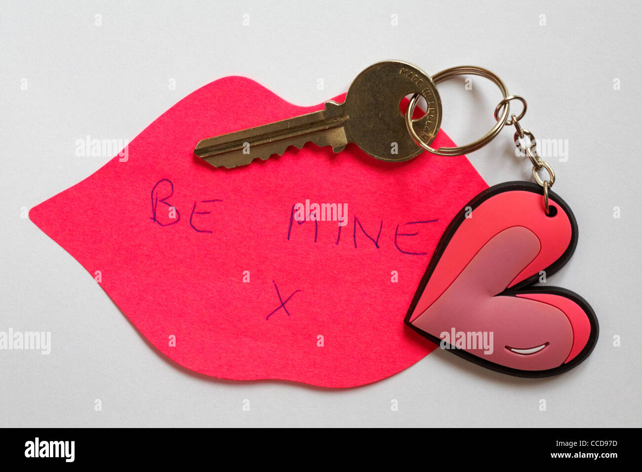 Be mine written on pink lip shaped post it note with door key on heart ...