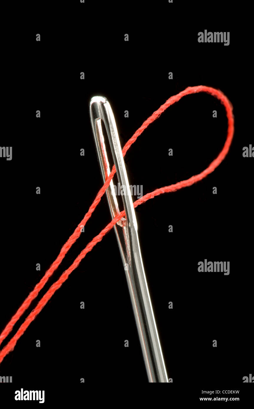 Sewing needle with red thread Stock Photo - Alamy