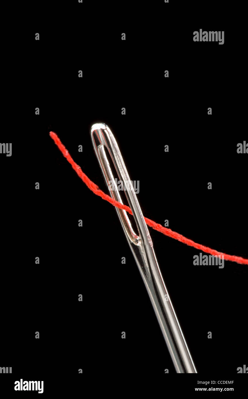 Sewing needle with red thread Stock Photo - Alamy