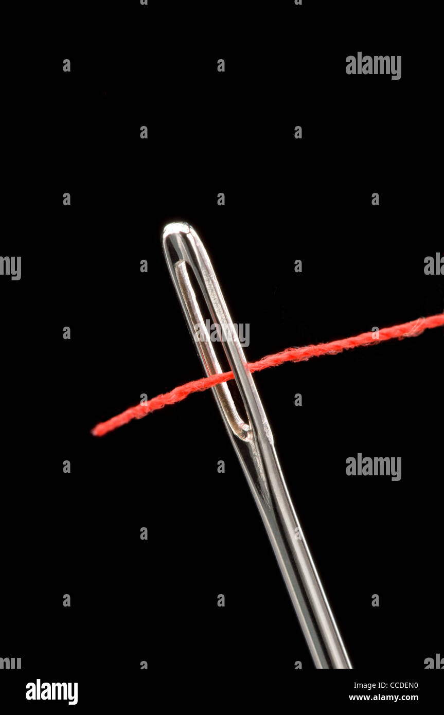 Sewing needle with red thread Stock Photo - Alamy