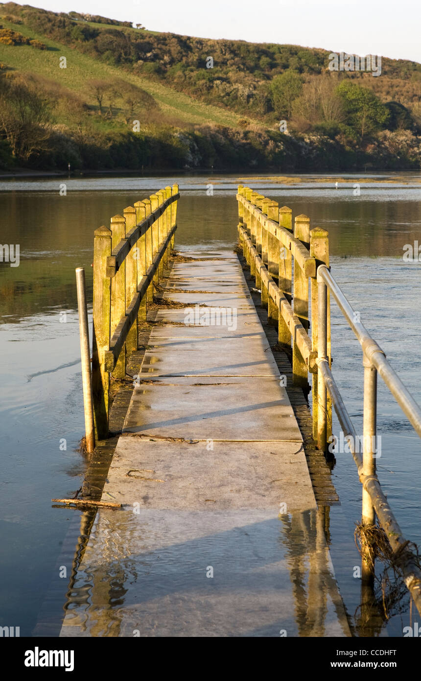 A walkway which is partially submerged by the incoming tide on the ...